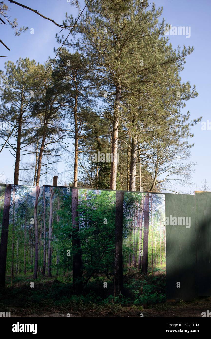 A billboard / hoarding featuring images of trees, in front of a ...