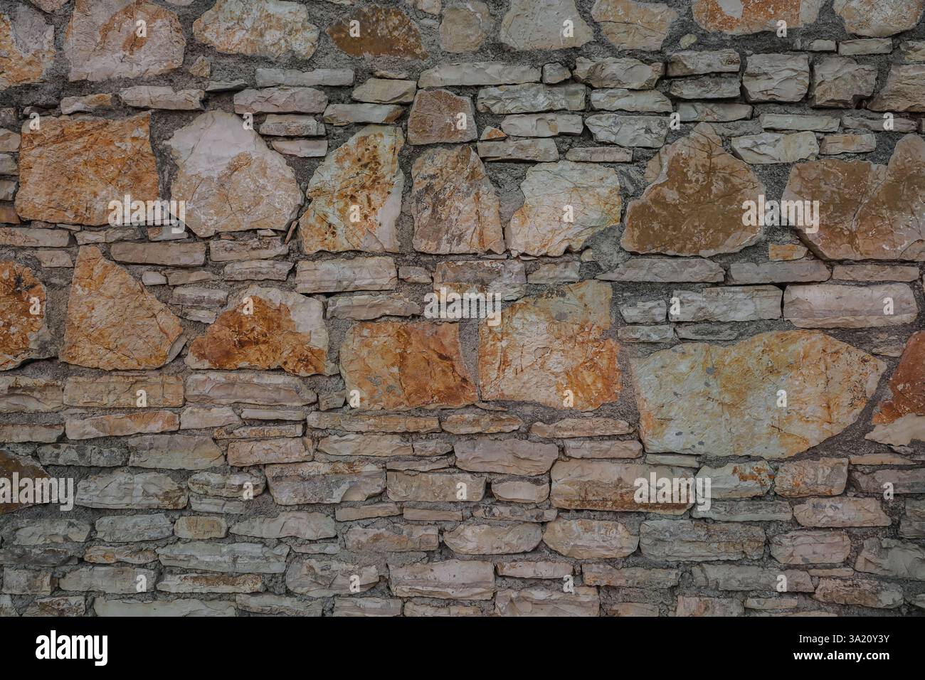 A textured stone wall in Albania displays a fascinating arrangement of ...