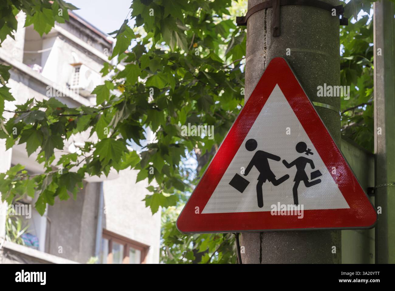 A warning sign alerts drivers to watch for children crossing the street ...