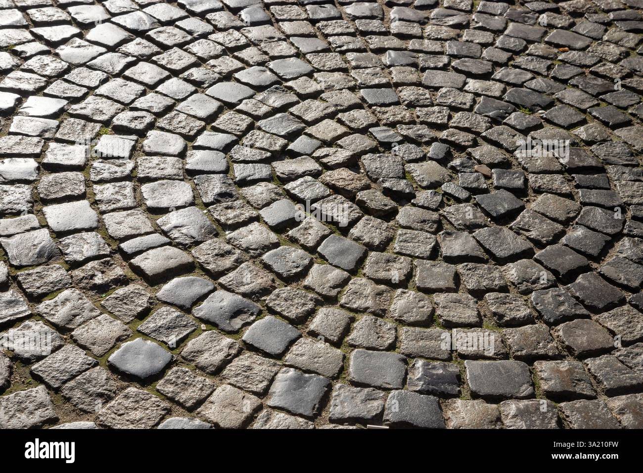Close view of a swirling cobblestone design created with uneven stones ...