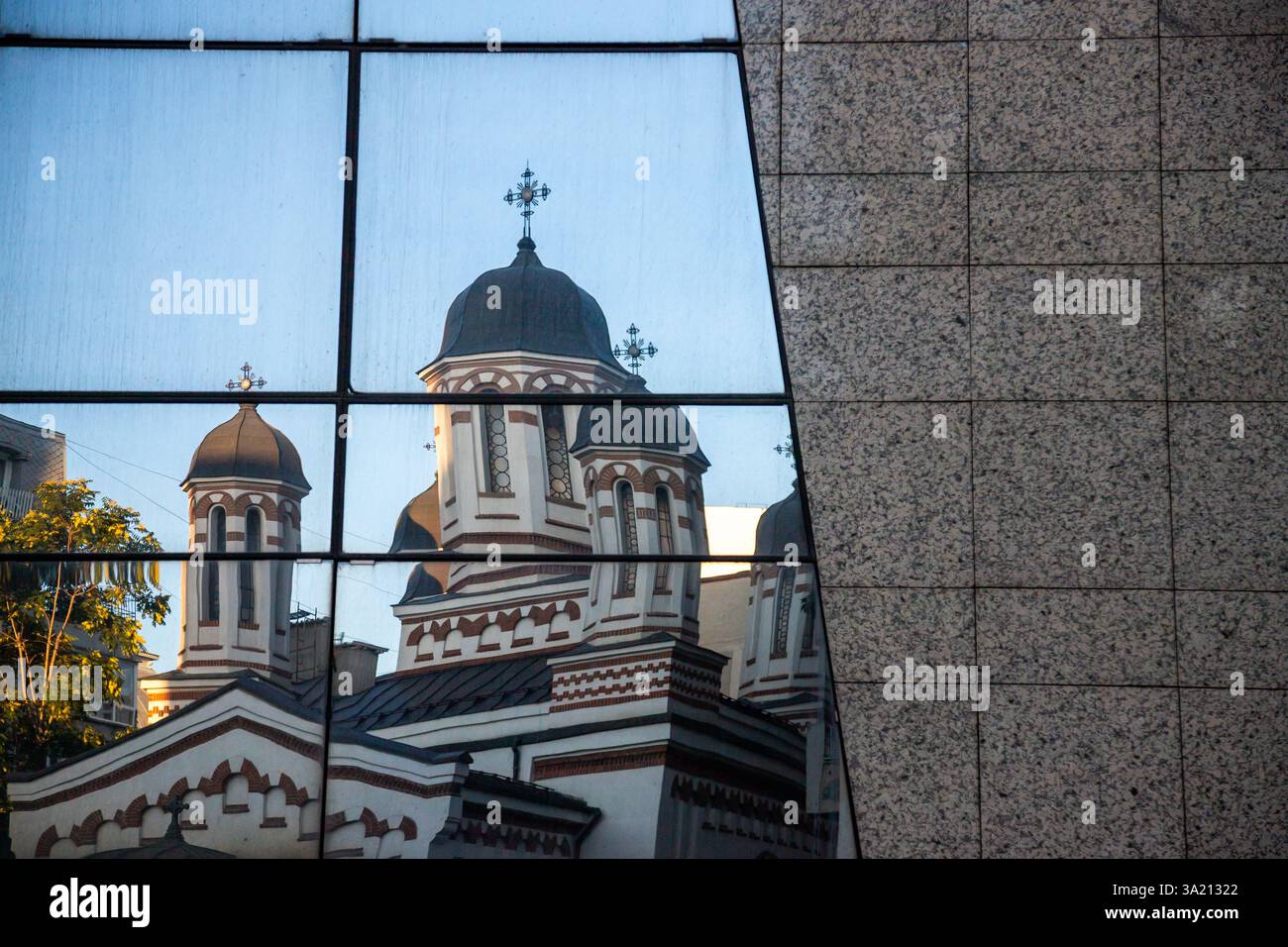 Historic church domes are reflected in contemporary glass facades in ...