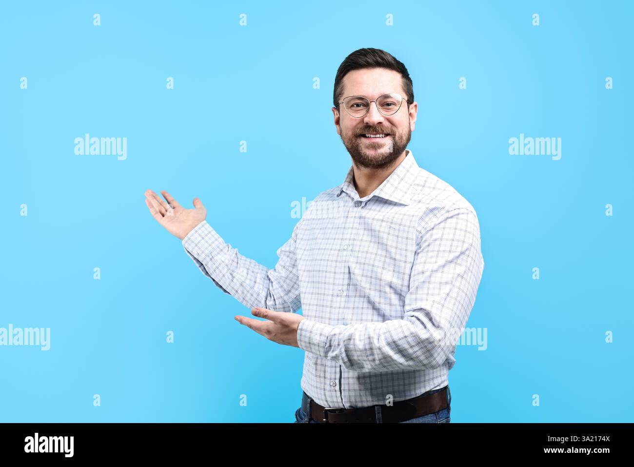 Happy man welcoming friends or guests on light blue background Stock ...