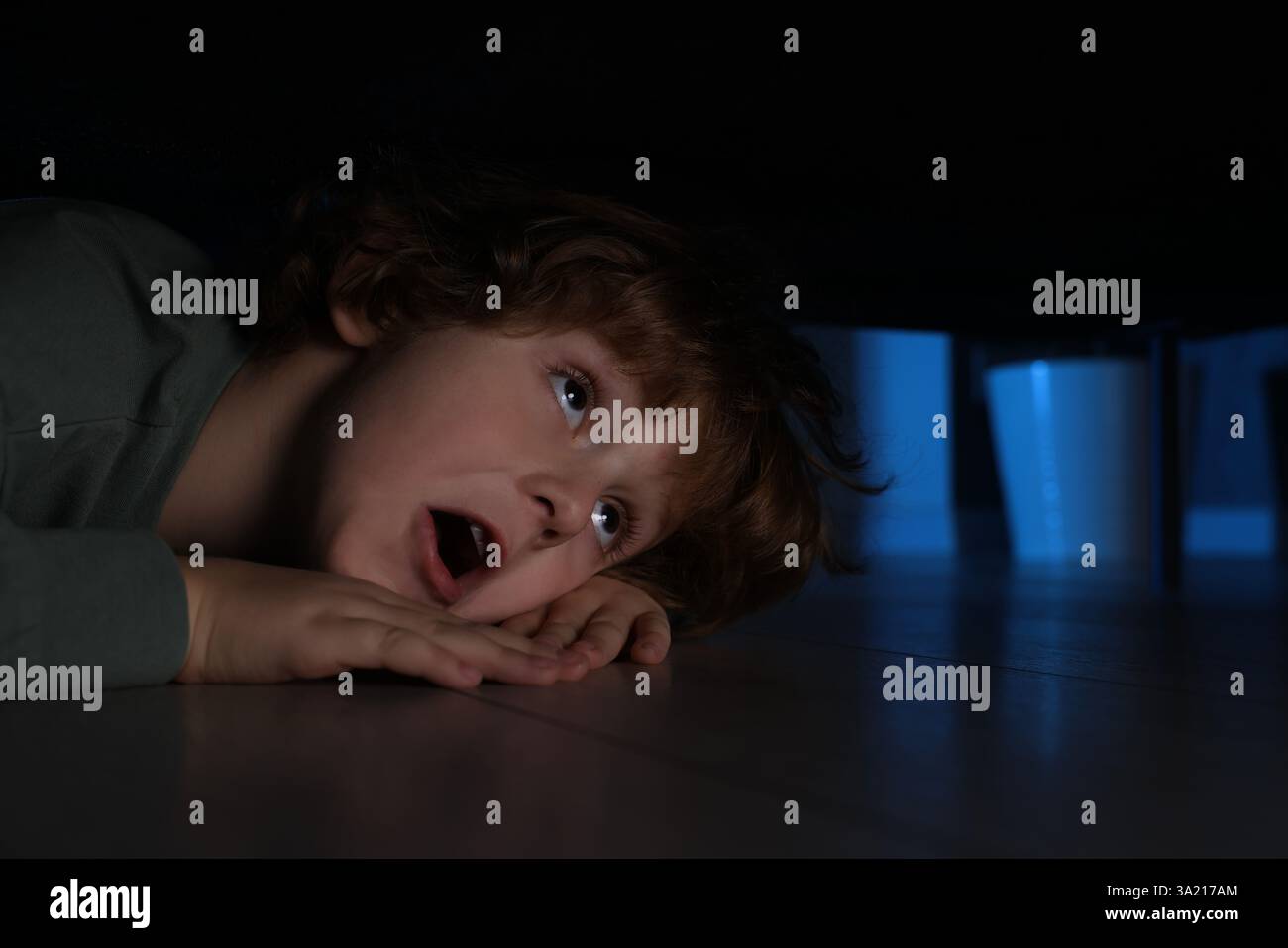 Fearful boy hiding under bed at night Stock Photo - Alamy