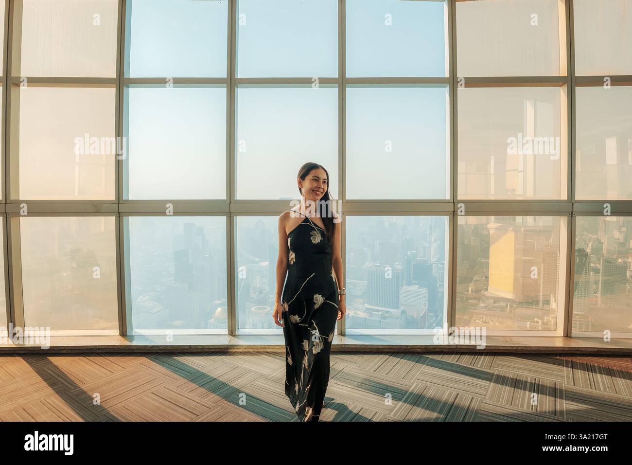 Beautiful asian stylish woman in black dress enjoying a scenic city ...