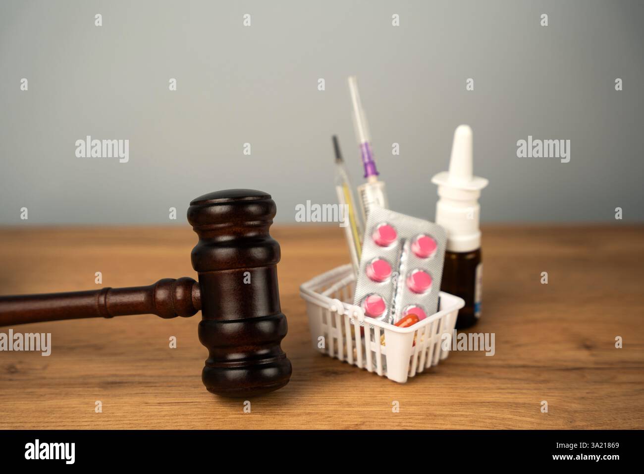 Judge gavel and basket with medical pills, a thermometer and a syringe ...