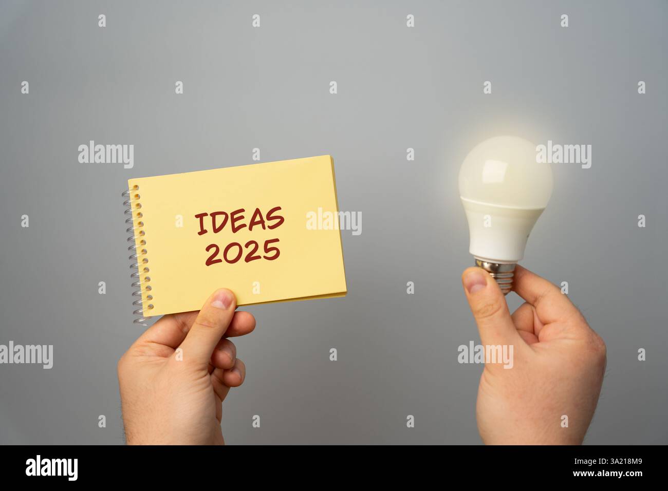 Ideas 2025 concept. Man holding a lamp and a notebook in his hands ...