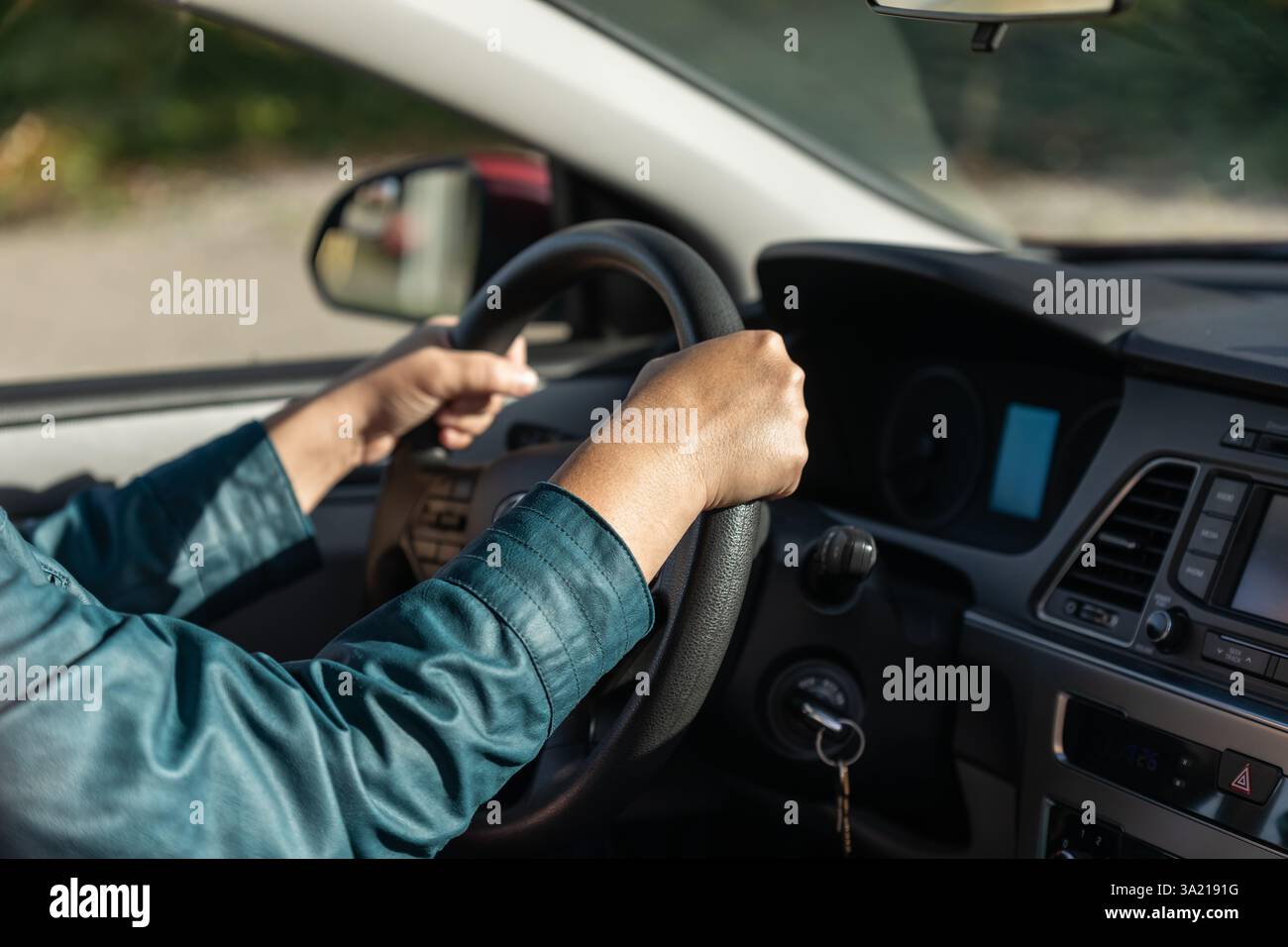 Person driving with both hands on the steering wheel. Female driver ...