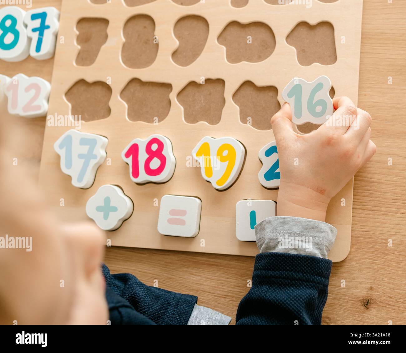 boy learns to count by laying out numbers from 1 to 20 on the board ...