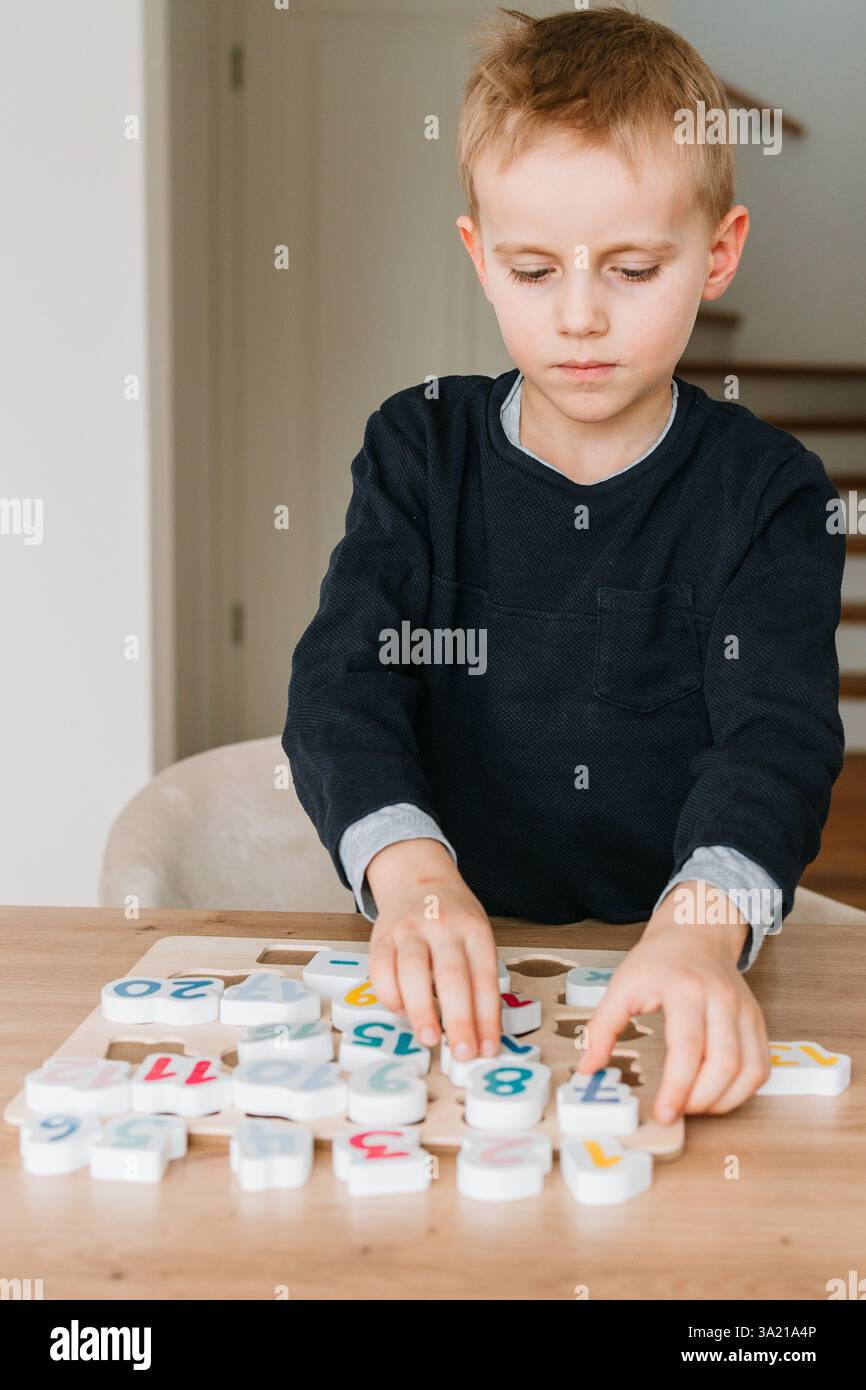 boy learns to count by laying out numbers from 1 to 20 on the board ...
