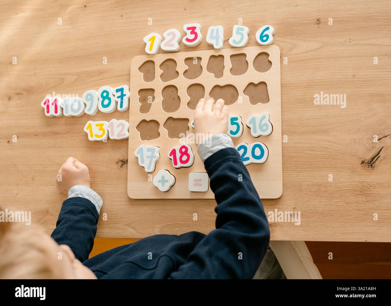 boy learns to count by laying out numbers from 1 to 20 on the board ...