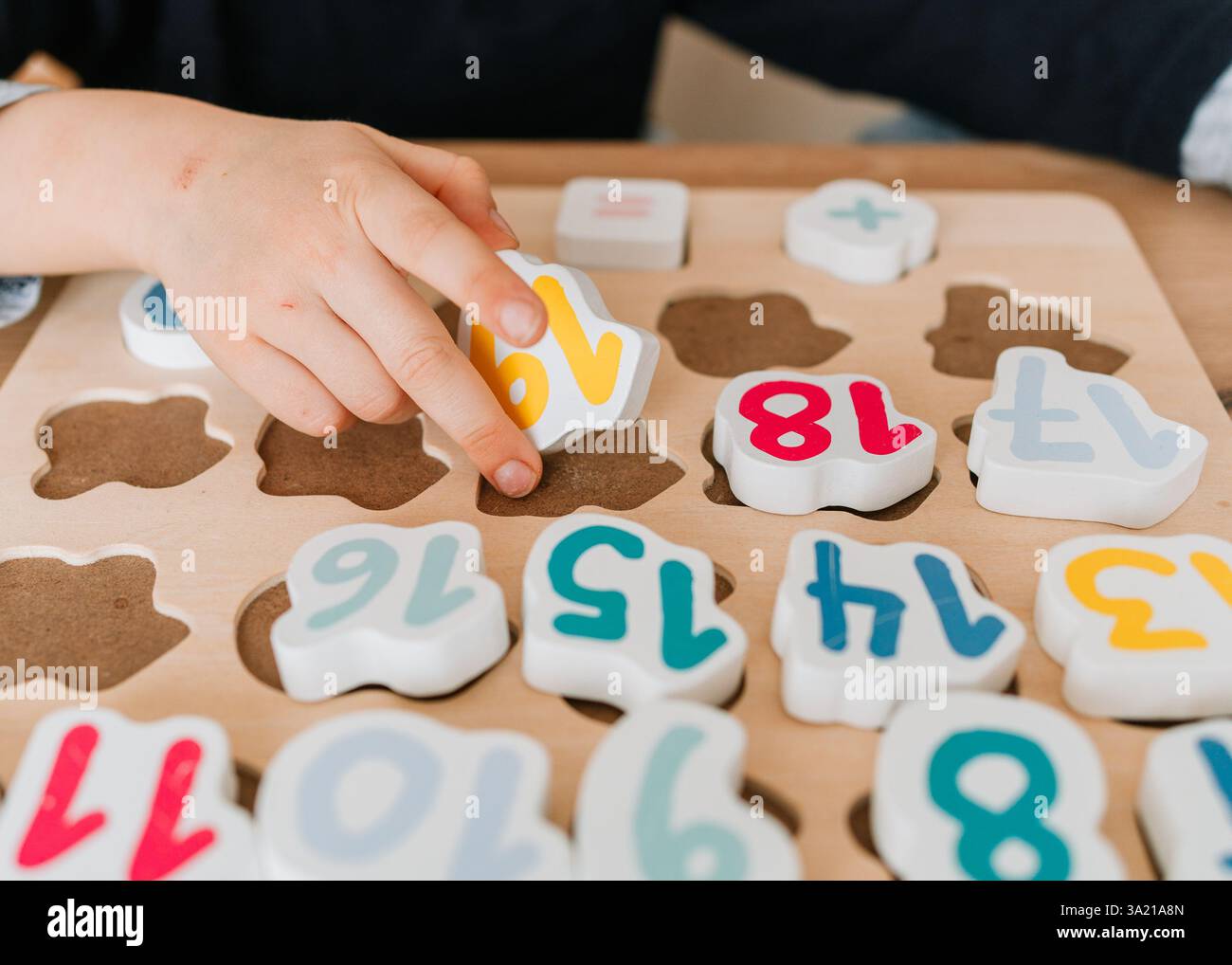 boy learns to count by laying out numbers from 1 to 20 on the board ...
