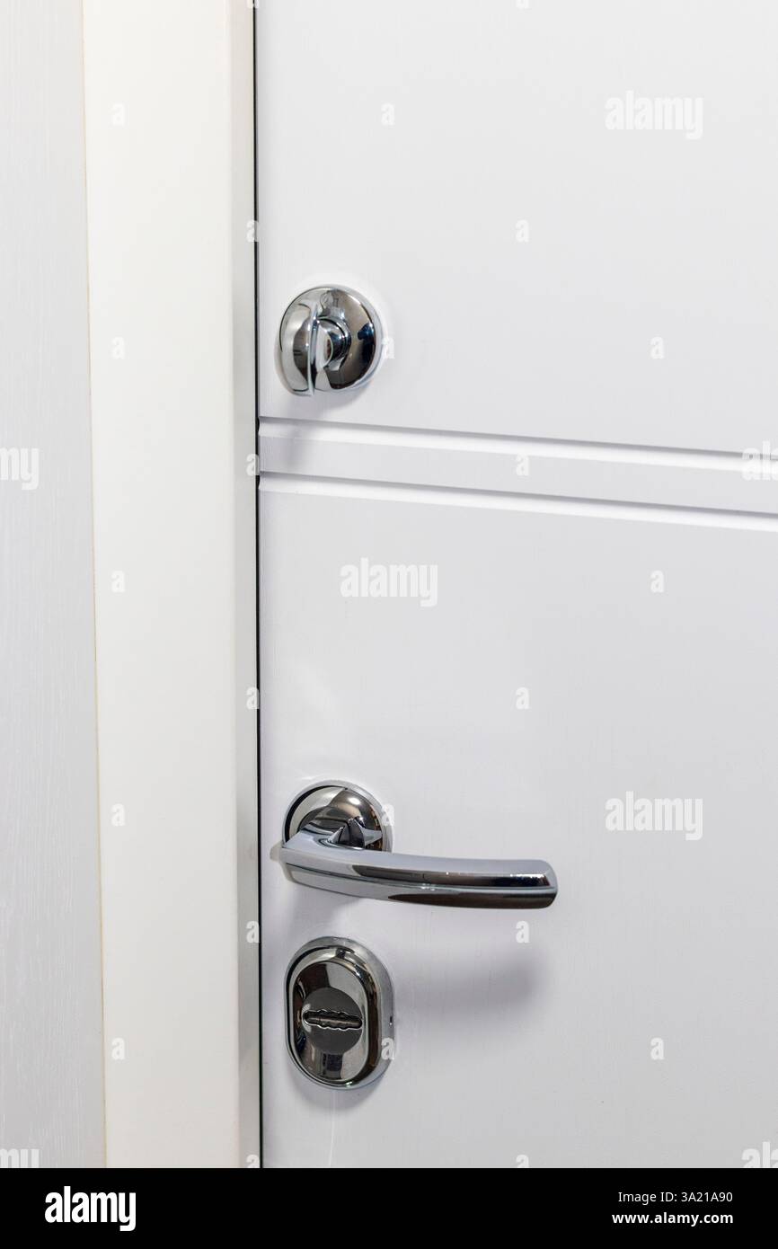 White door with metal handle and locks as a part of interior design ...