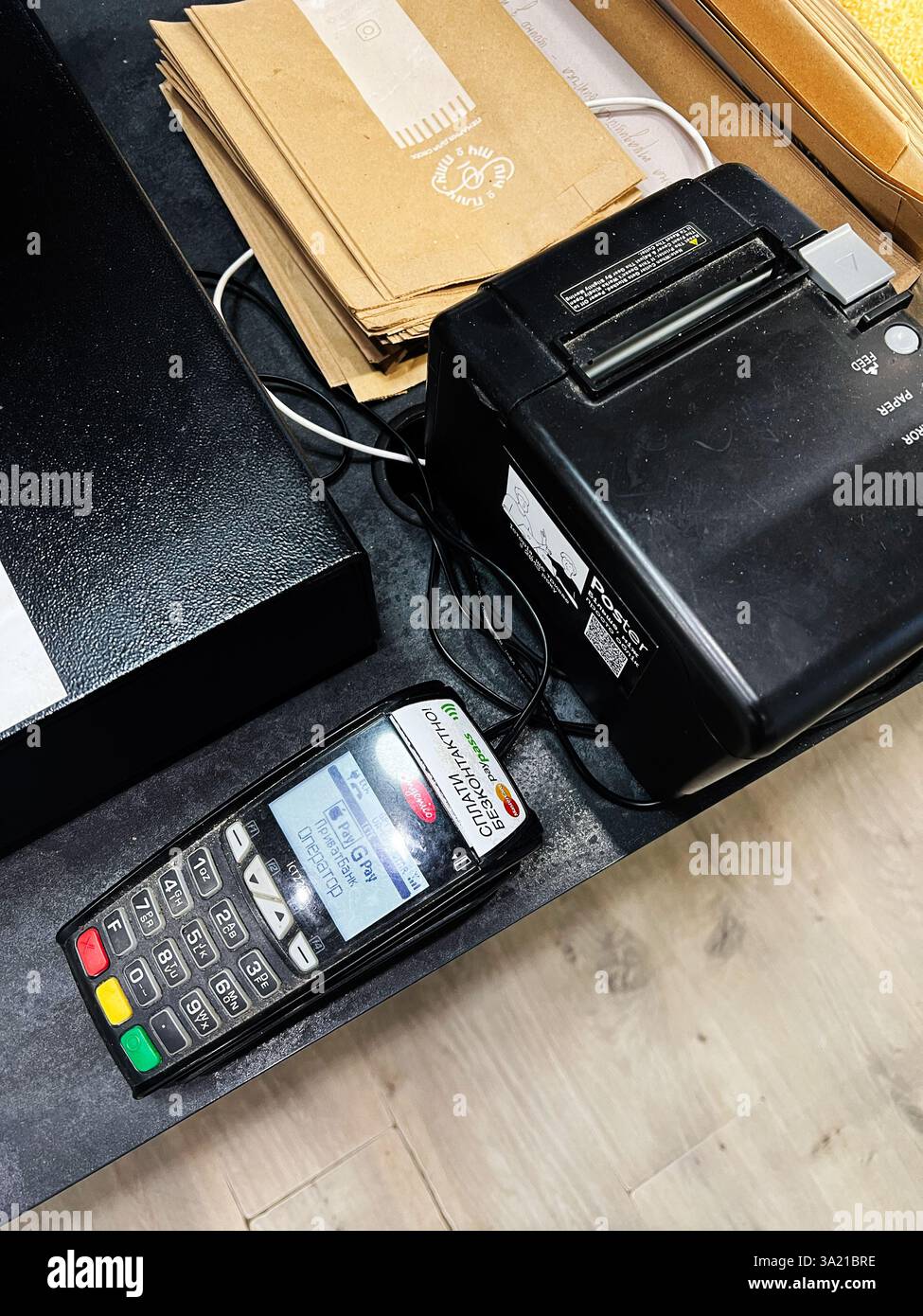 Kyiv, Ukraine - March 10, 2025: Point of sale machine and receipt printer on a store desk for ...