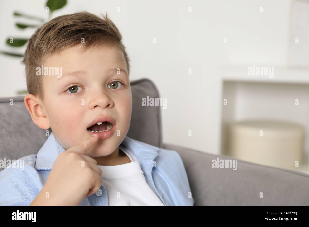 Cute little boy pointing at his missing tooth indoors Stock Photo - Alamy