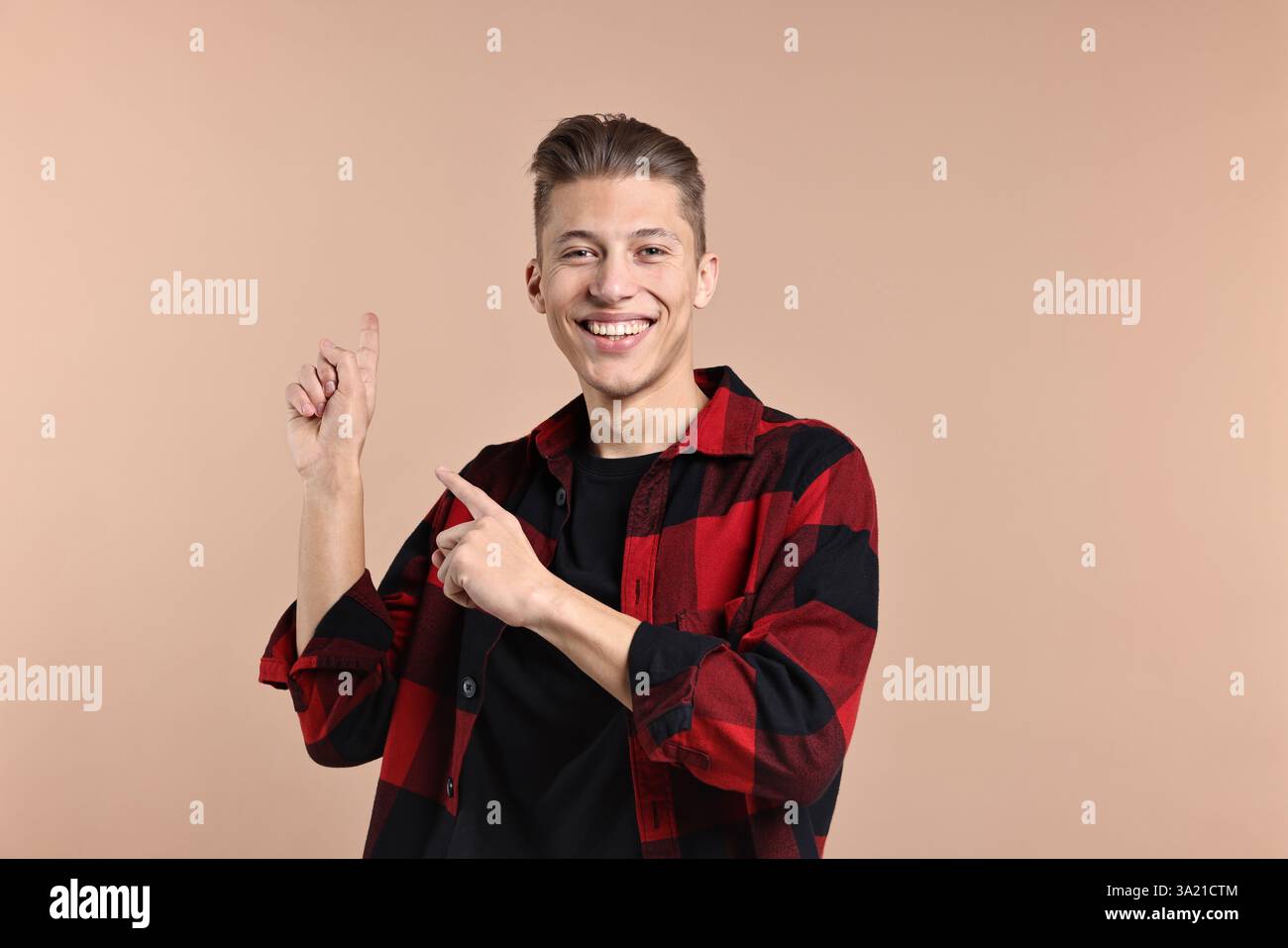 Happy man welcoming friends or guests on beige background Stock Photo ...