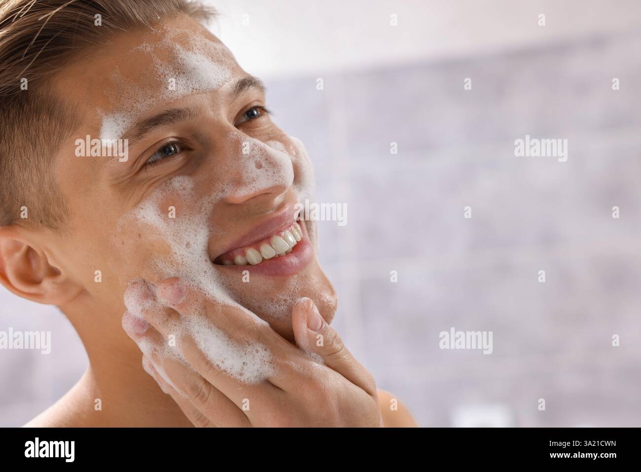 Man washing his face with cosmetic product in bathroom, closeup. Space for text Stock Photo - Alamy