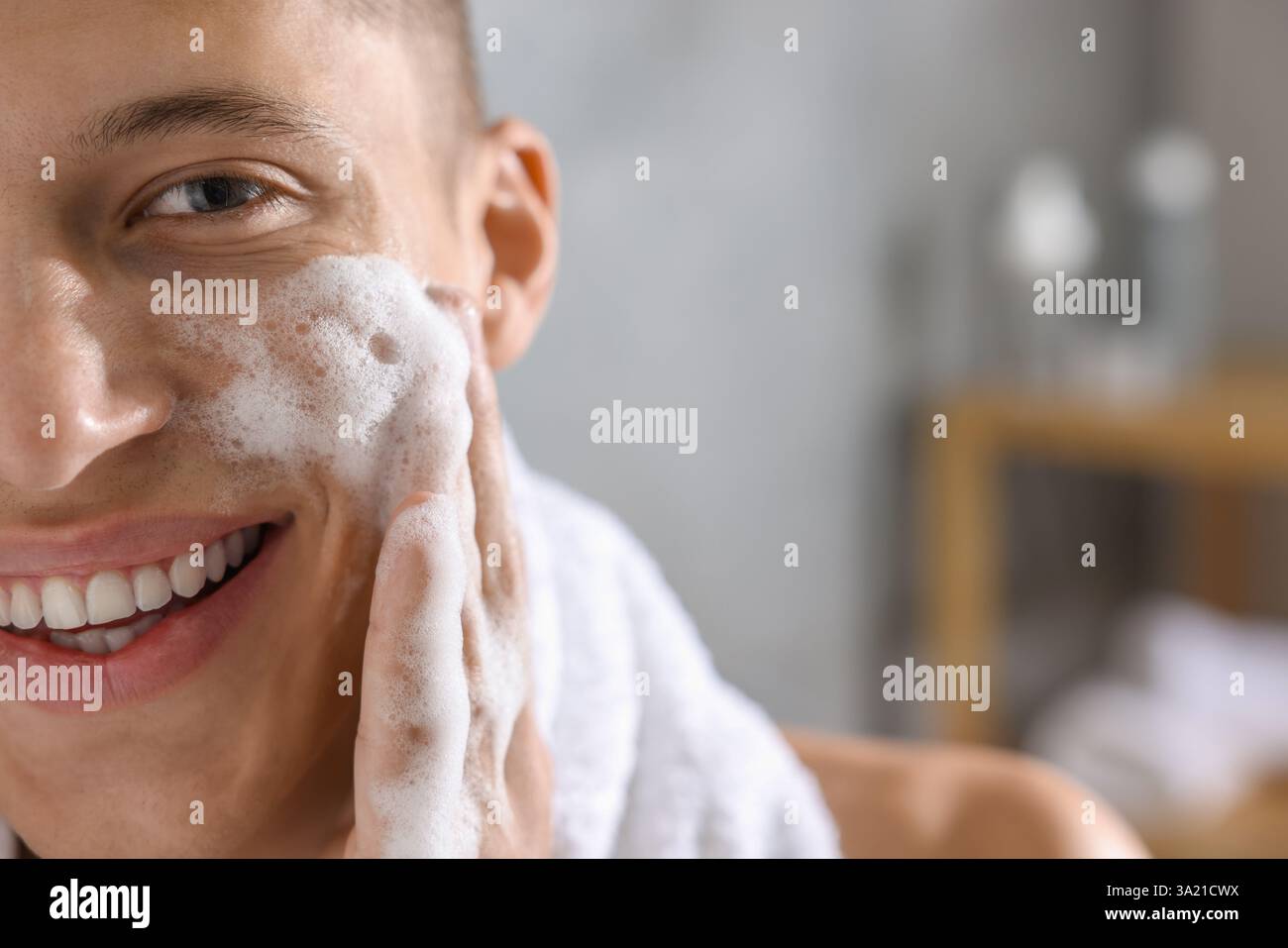 Man washing his face with cosmetic product in bathroom, closeup. Space for text Stock Photo - Alamy