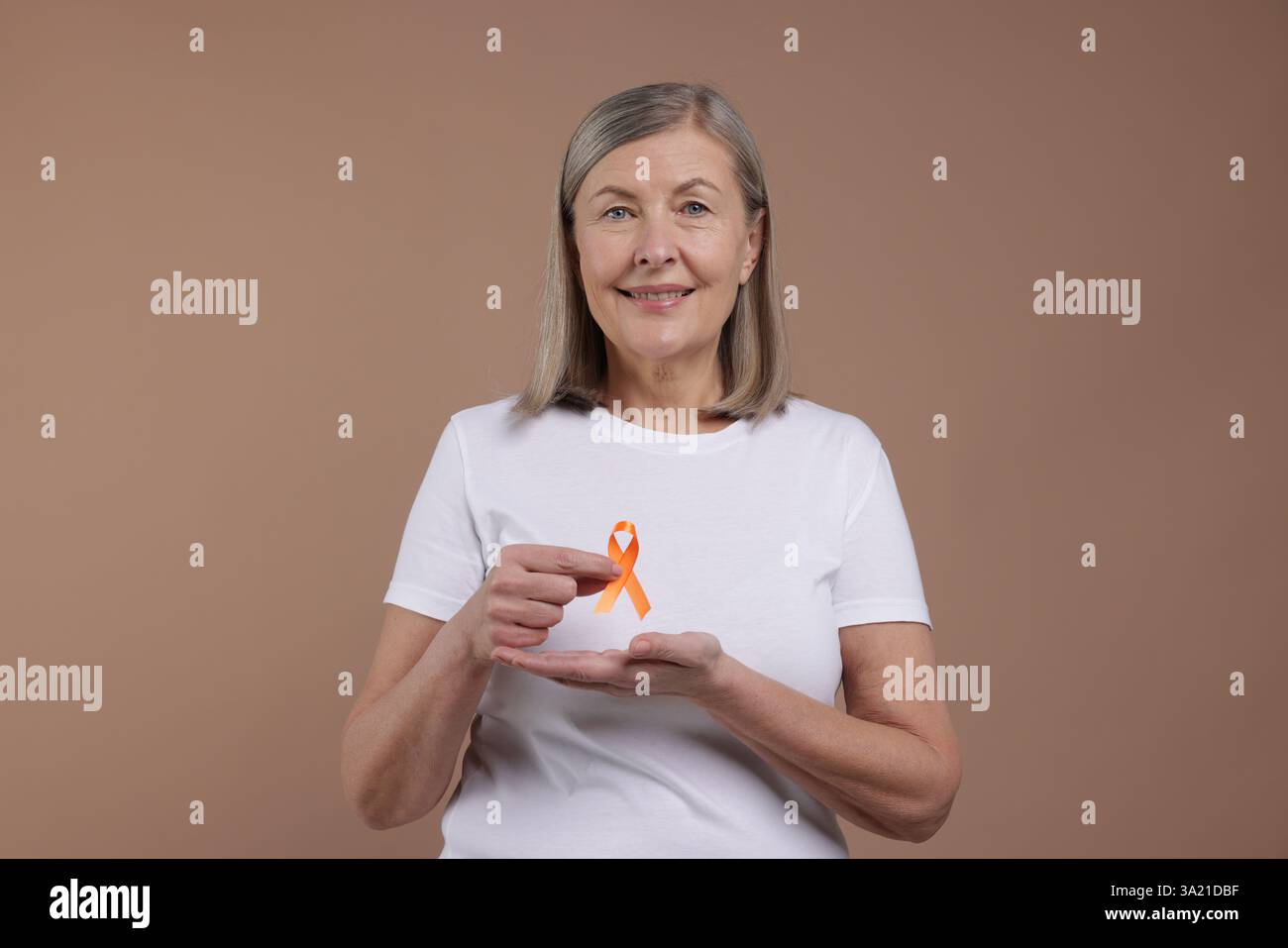 Multiple Sclerosis awareness. Woman with orange ribbon on brown ...