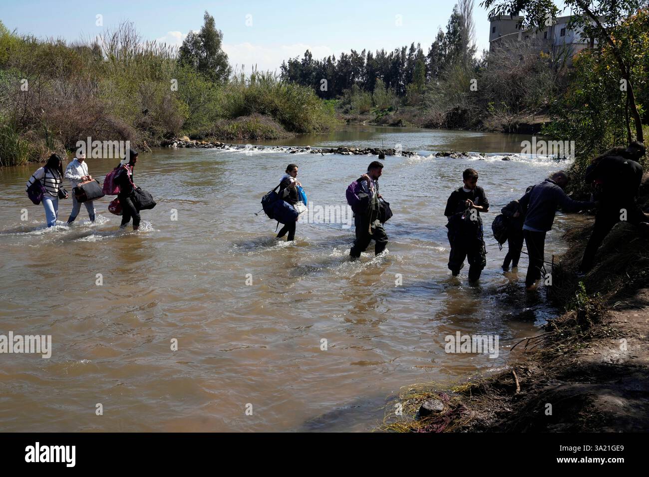 Syrian families who fled the clashes in Syria hold their luggages as ...
