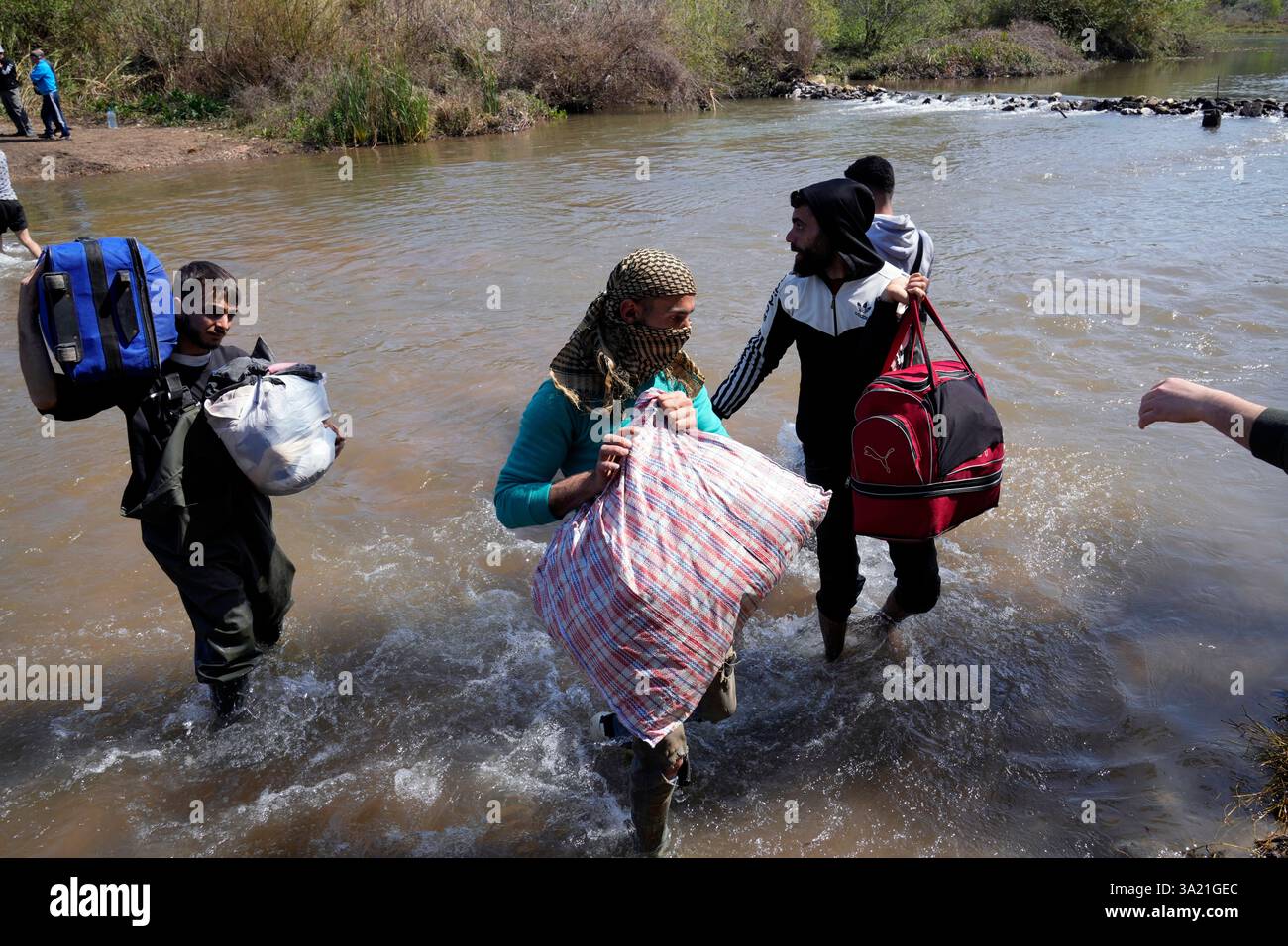 Syrian families who fled the clashes in Syria hold their luggages as ...