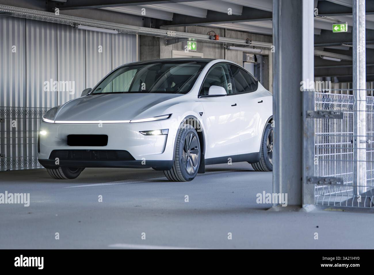 White electric car with modern lines and LED lights in a multi-storey ...