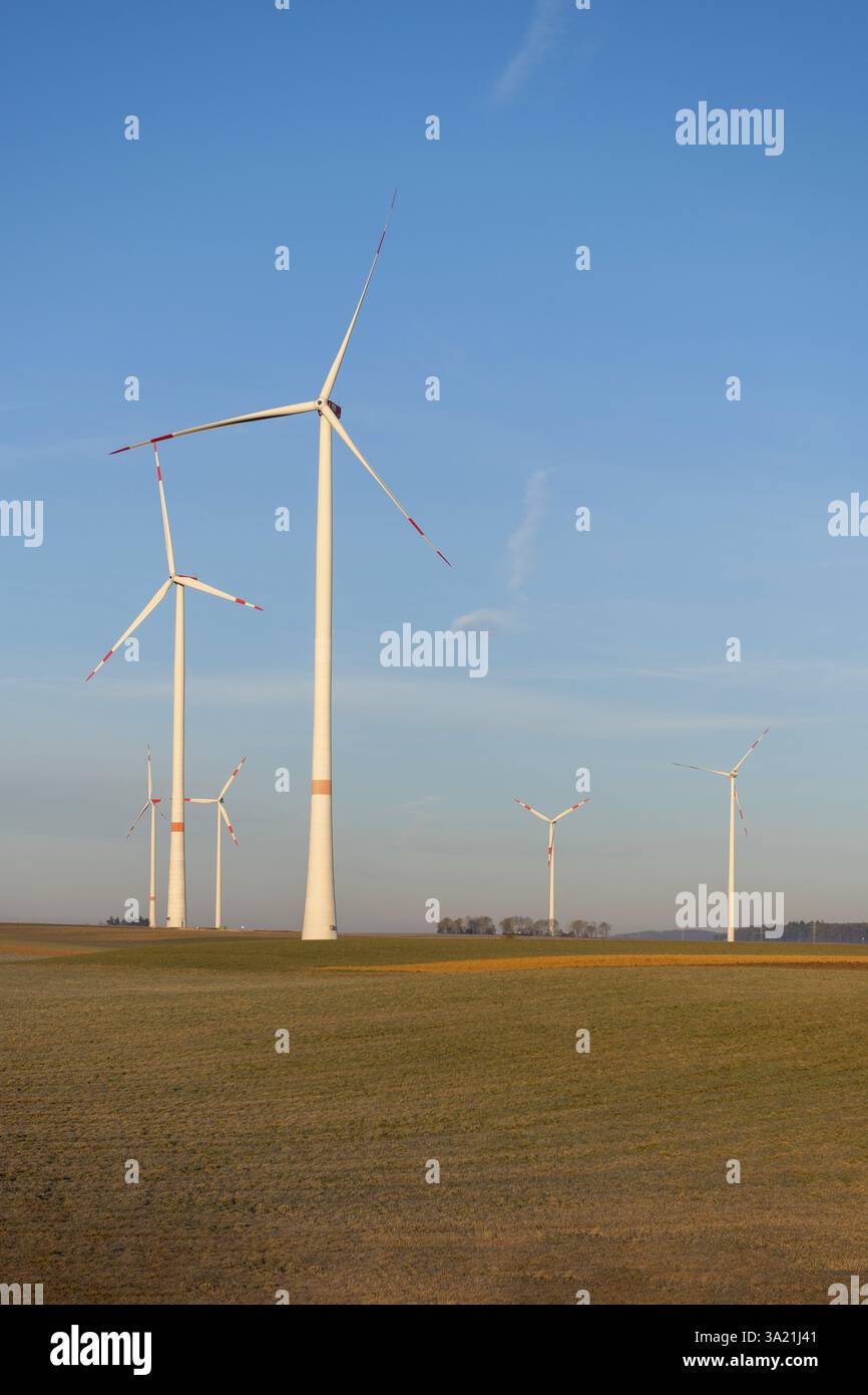 Wind turbines in an open green landscape under a calm sky, solar park ...