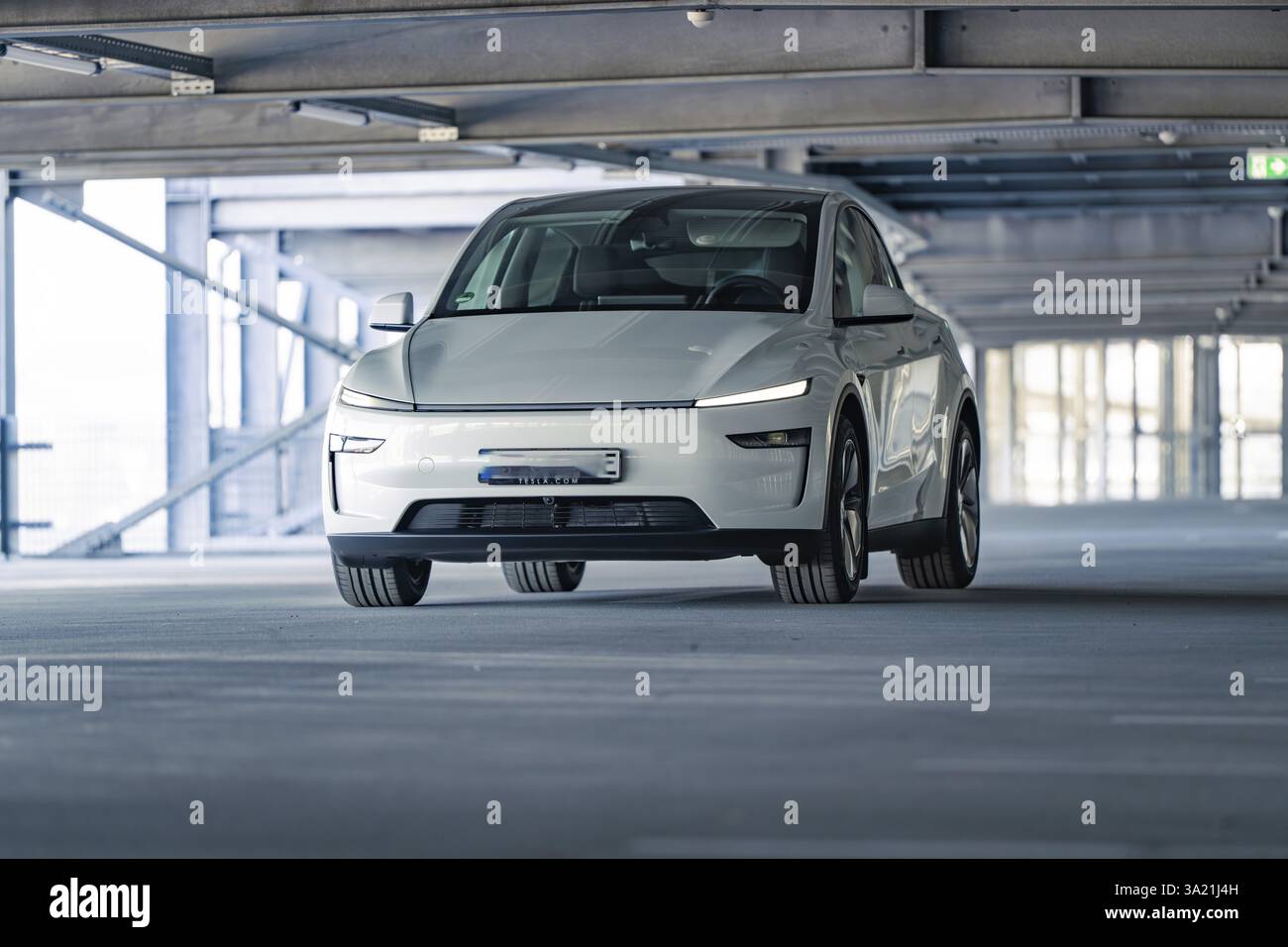 Electric car with modern shapes in a dimly lit car park, Tesla New ...