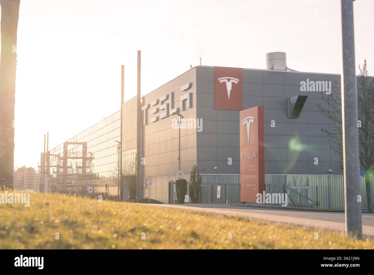 Modern Tesla building with grey facade and large logo in the sunlight ...