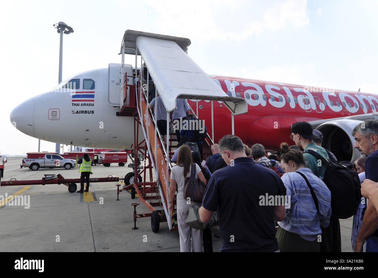 Passengers board a Thai AIRASIA Airbus via a gangway on the apron of ...