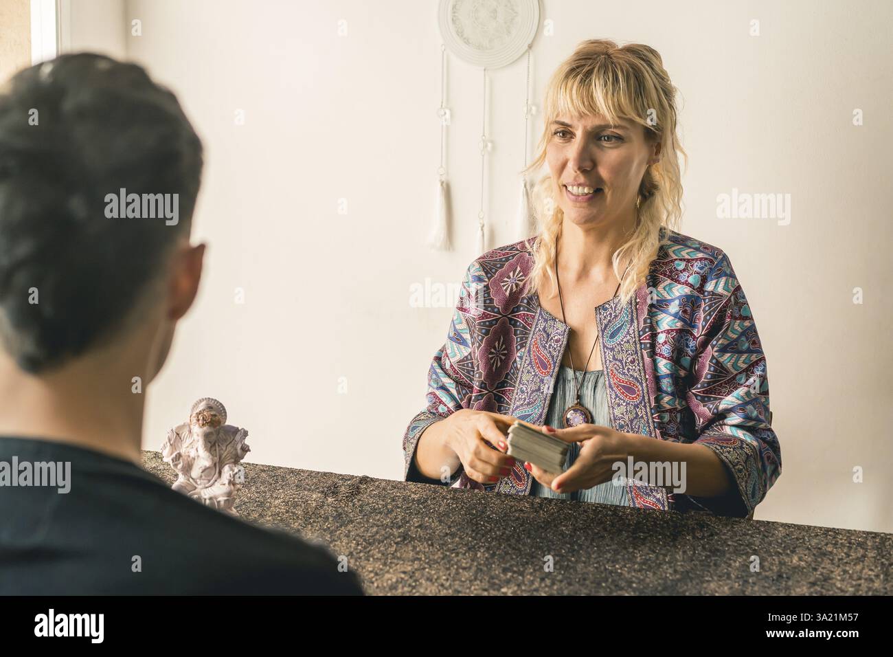Tarot reader mixing the tarot deck in front of her male client Stock ...