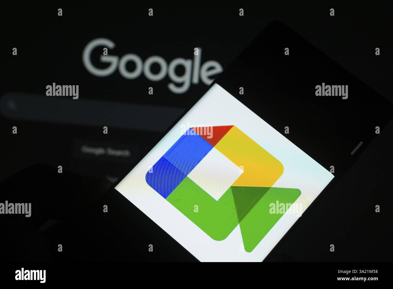 Google Meet on screen in front of website. Focus on phone display ...