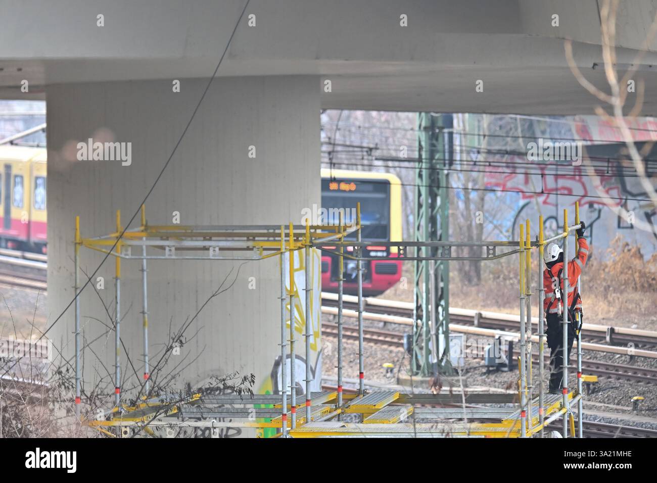 11 March 2025, Berlin: Construction workers are erecting scaffolding on a highway bridge on the ...