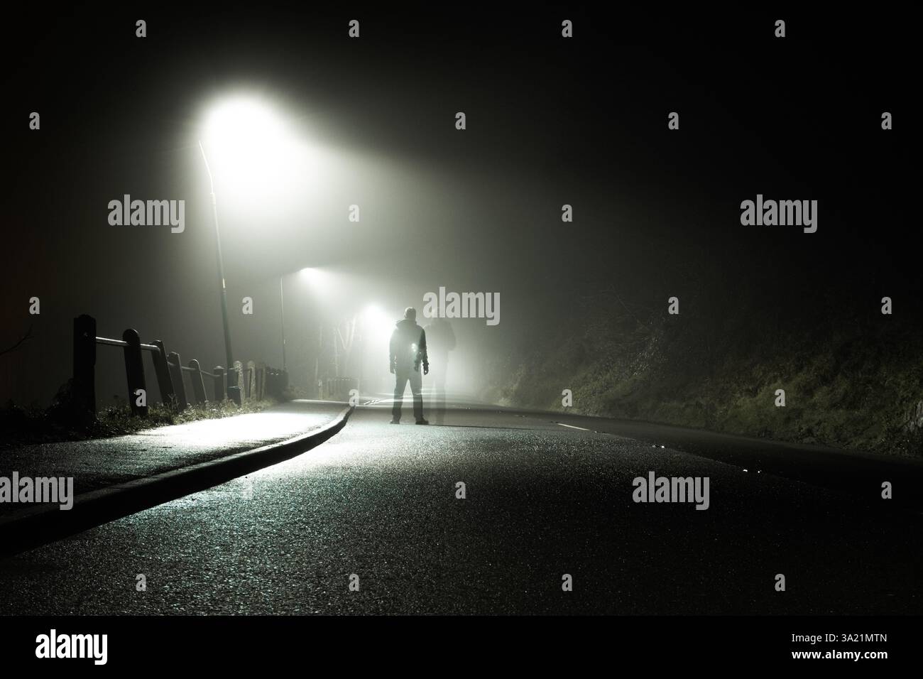 An eerie transparent ghost like figure standing on ampty road ...
