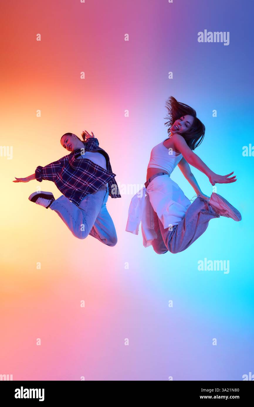 Two energetic young women showcasing bold hip hop moves against vibrant ...