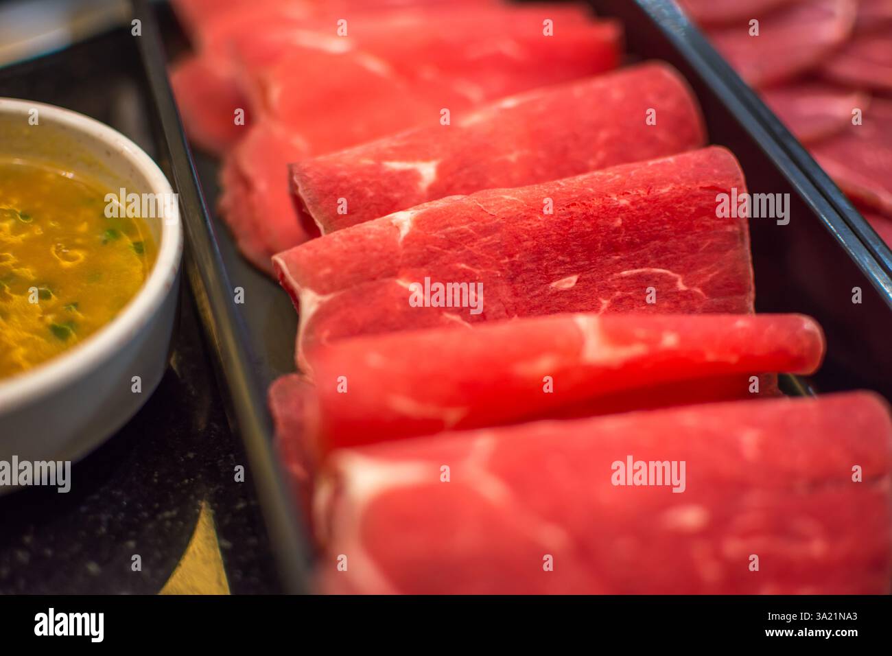 Beef raw meat slides on dish with barbecue sauce at BBQ. yakiniku grill ...