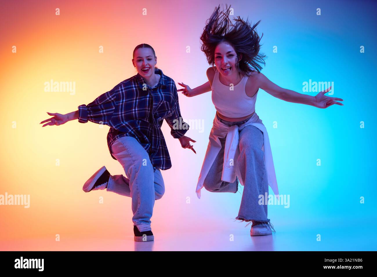 Stylish young women dancing hip hop in bold freestyle poses against ...