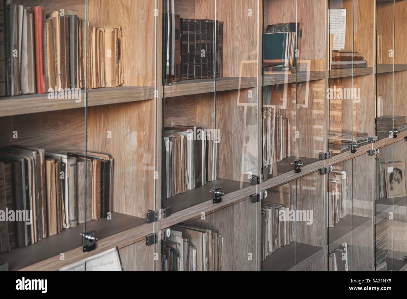 Bookshelf filled with antique books behind glass doors in historic ...