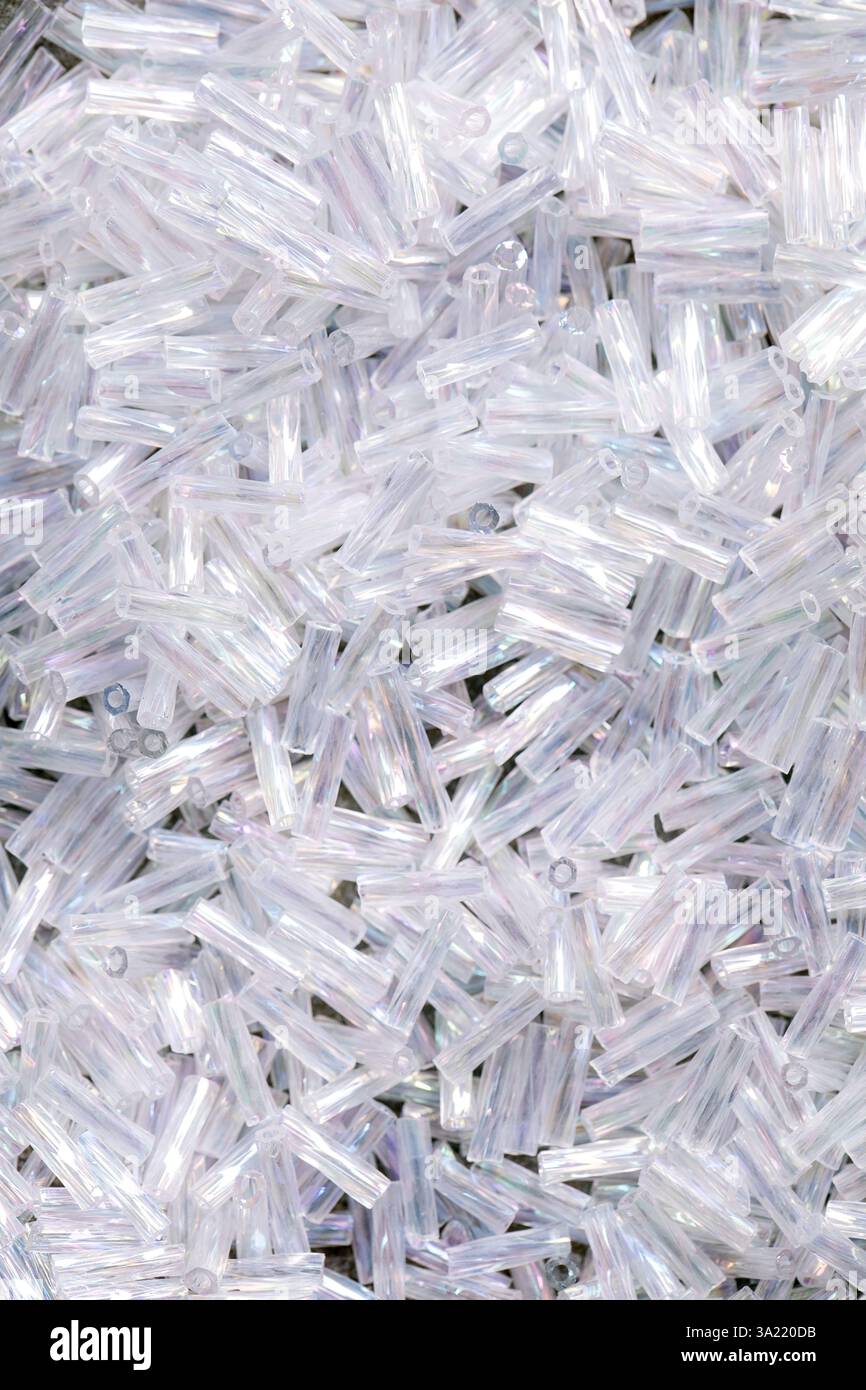 DIY hobby background with white pearlescent glass bugle beads Close-up ...