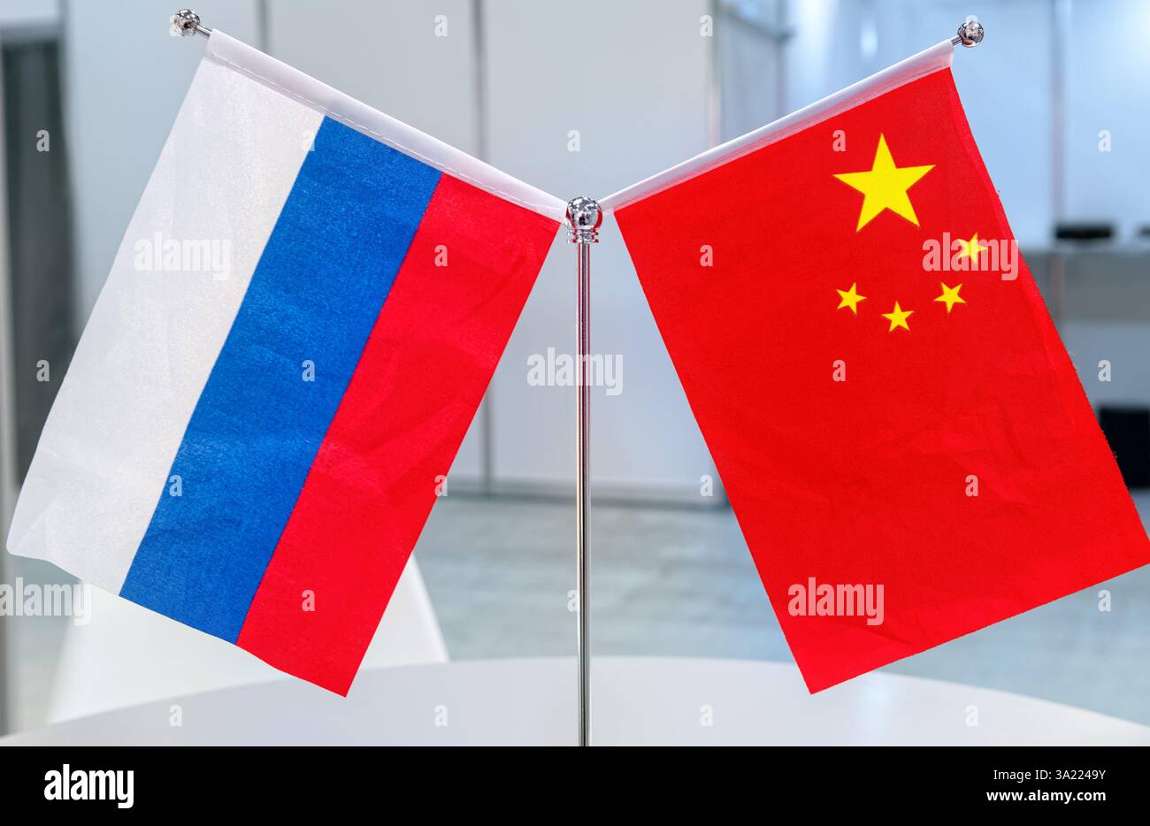 Russian and Chinese flags on table in meeting room. The concept of ...