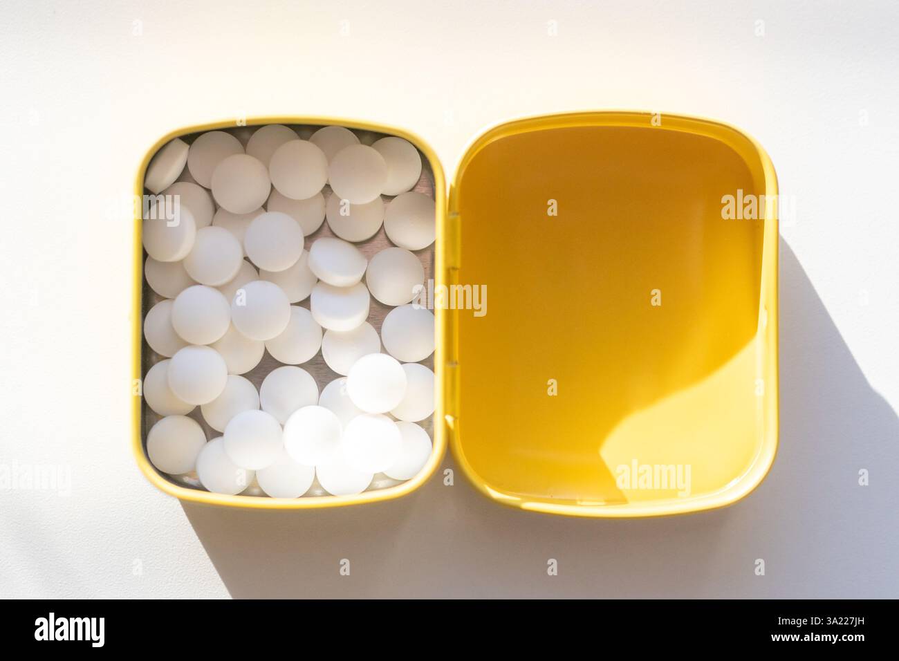 Yellow opened tin with mints on white background Stock Photo - Alamy