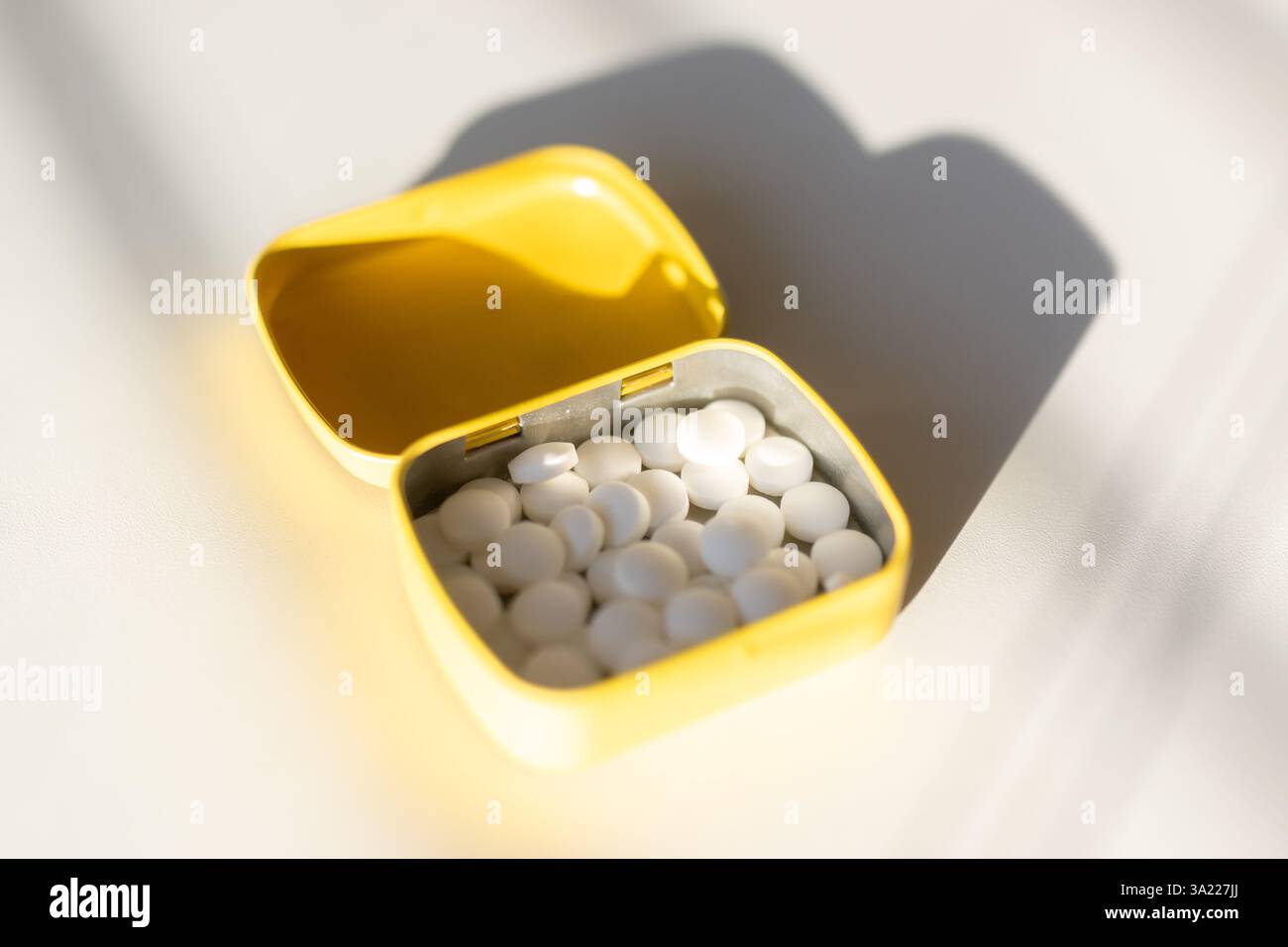 Yellow opened tin with mints on white background Stock Photo - Alamy