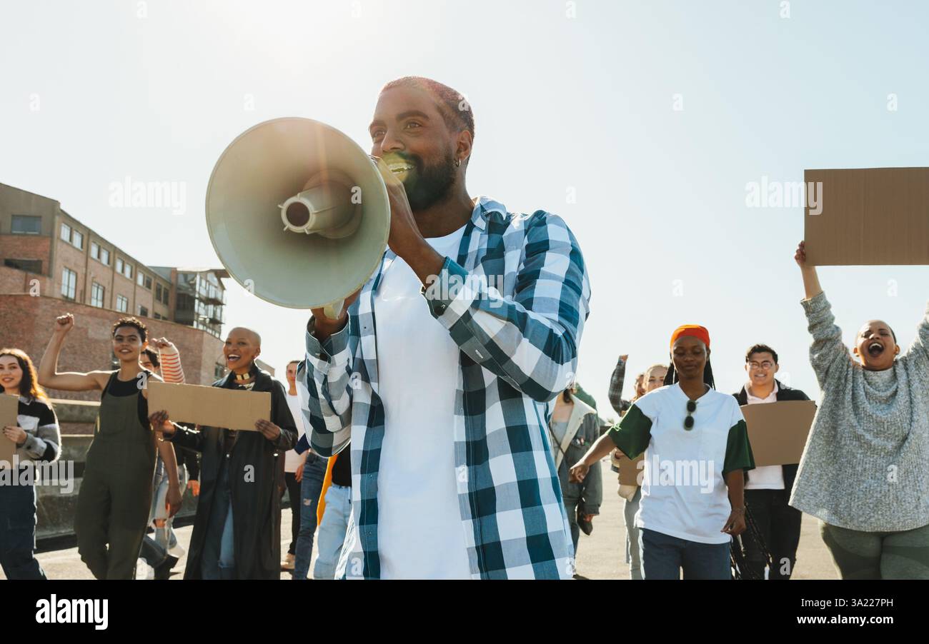A group of people marching together, holding signs and megaphones ...