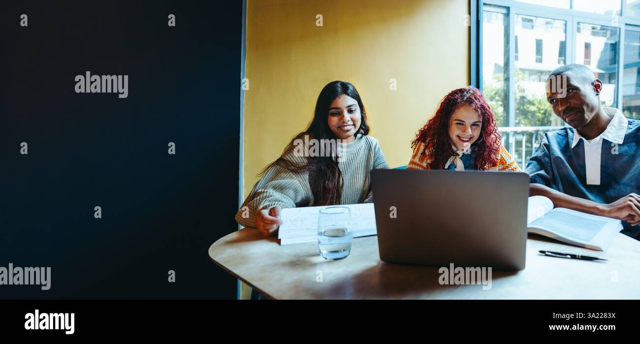 Three multicultural students studying together on campus, working with ...