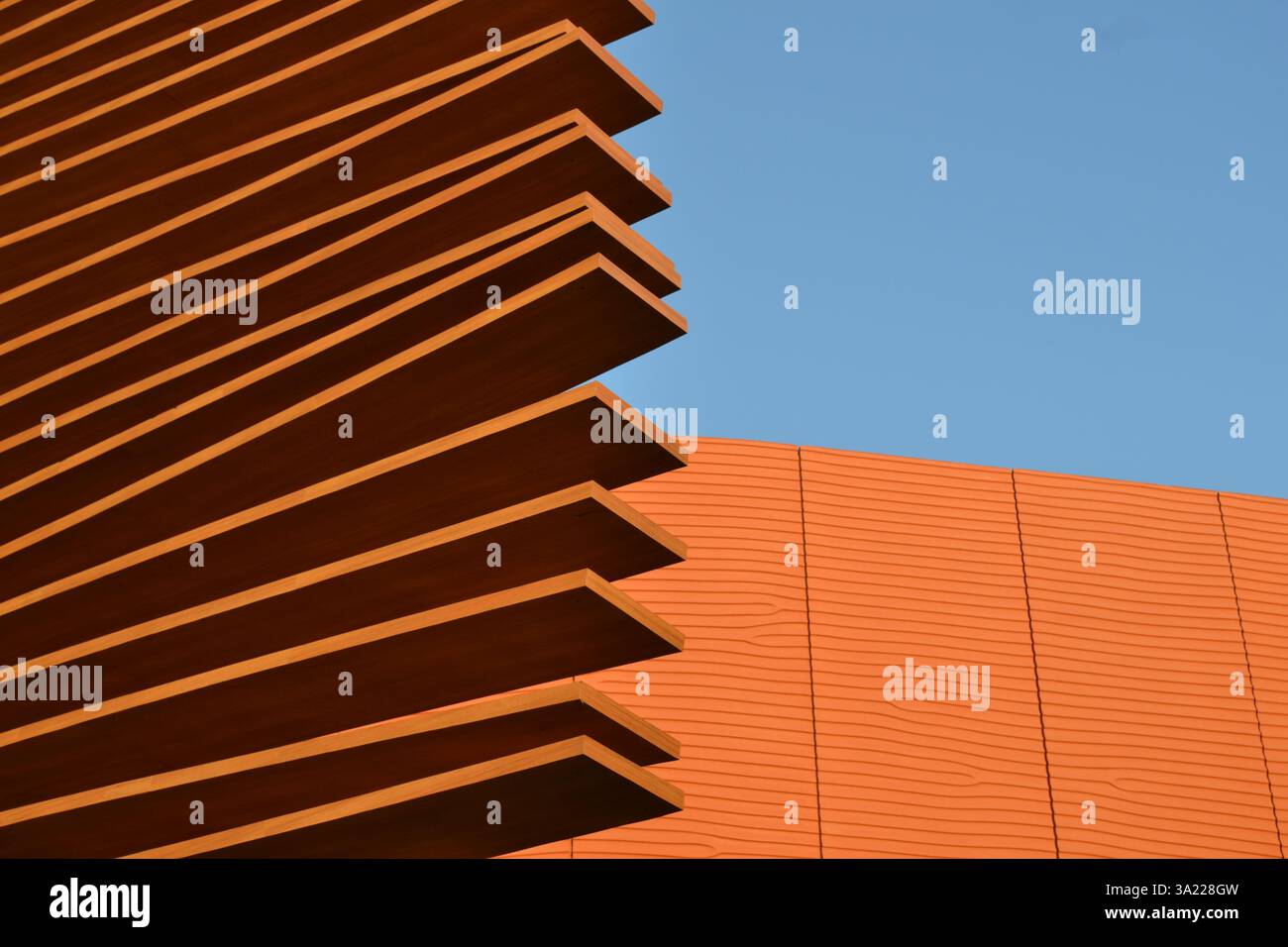 Heap of brown boards, red brick wall and blue sky. Abstract ...