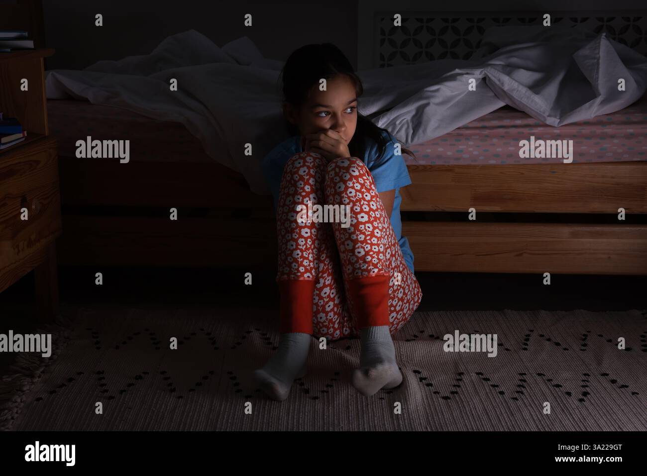 Afraid girl near bed in her room at night Stock Photo - Alamy