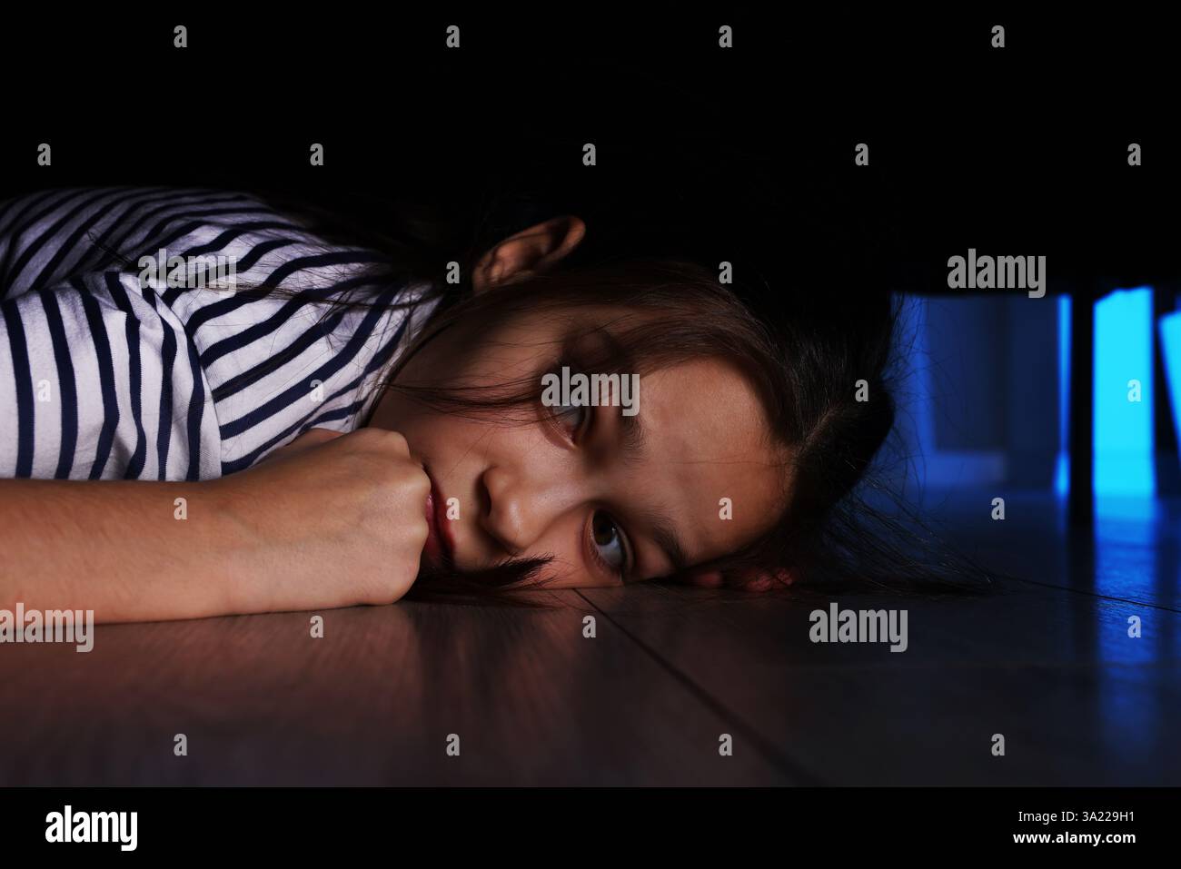 Fearful girl hiding under bed at night Stock Photo - Alamy