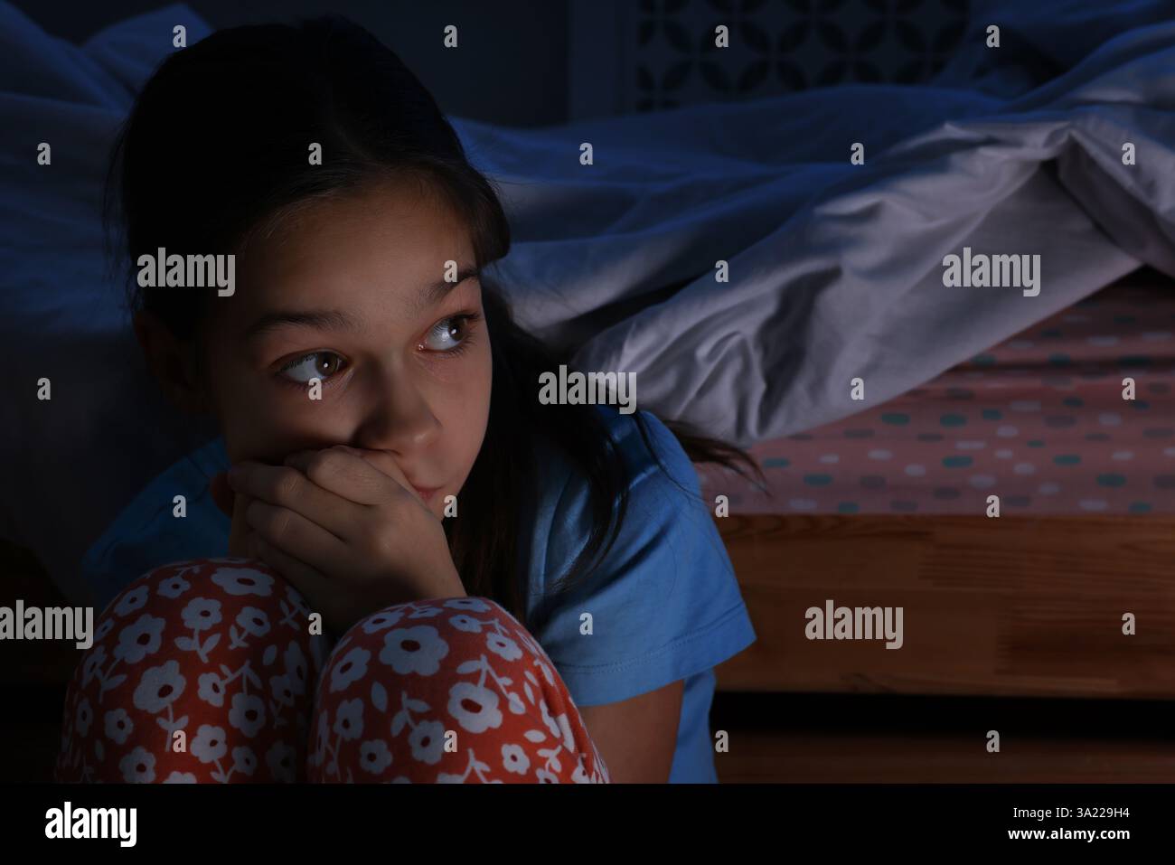 Afraid girl near bed in her room at night Stock Photo - Alamy