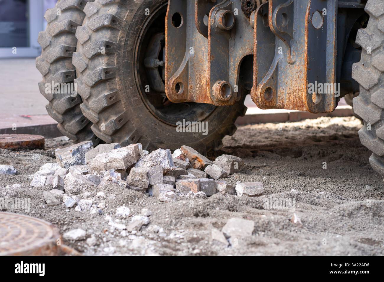 View of the remains of the old road surface under the wheels of a truck ...
