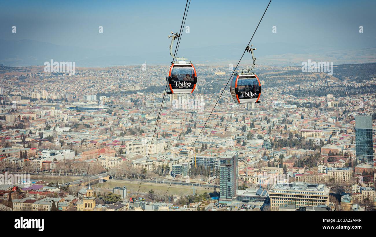 Modern cable cars moving above Tbilisi, Georgia, with a scenic ...