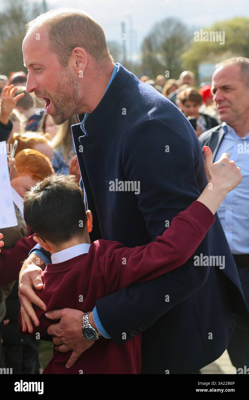 The Prince of Wales hugs a young well-wisher during a visit to a ...